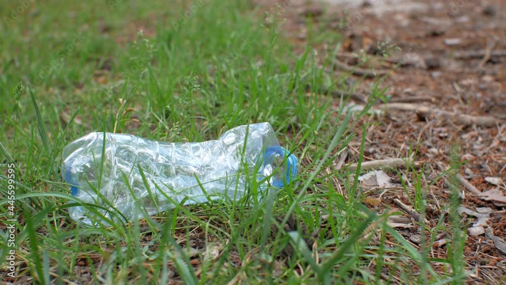 Woman to litter in the park. Throw out Plastic bottle around the trees ...