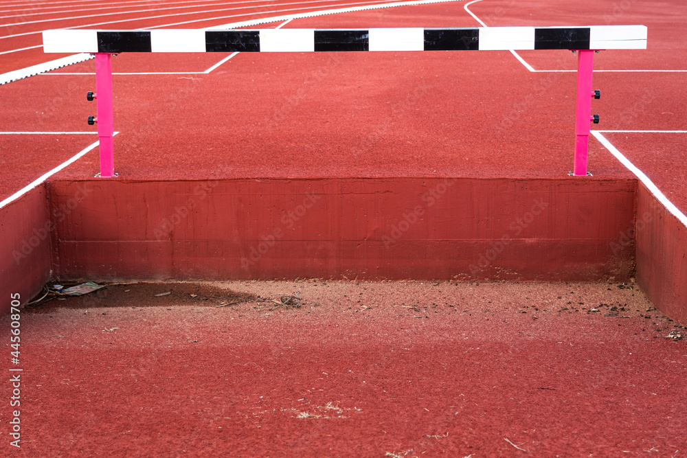 An obstacle fence for jumping over and the running race track and ...