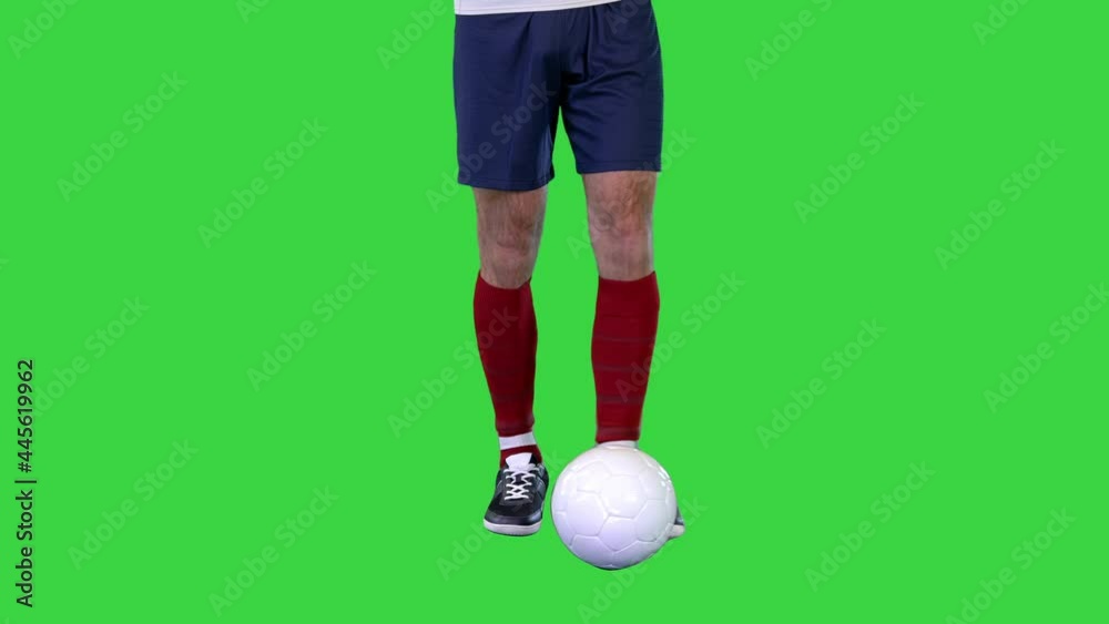 Feet of a football player walking slowly and kicking the ball on a ...
