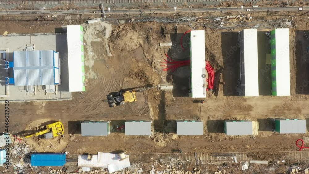 Aerial of powerful yellow excavator digging trench with bucket. Laying ...