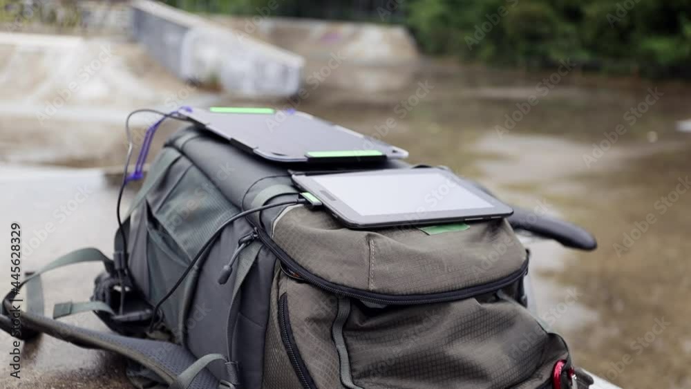 Concept of renewable energy. Tablet is charged from a portable solar ...