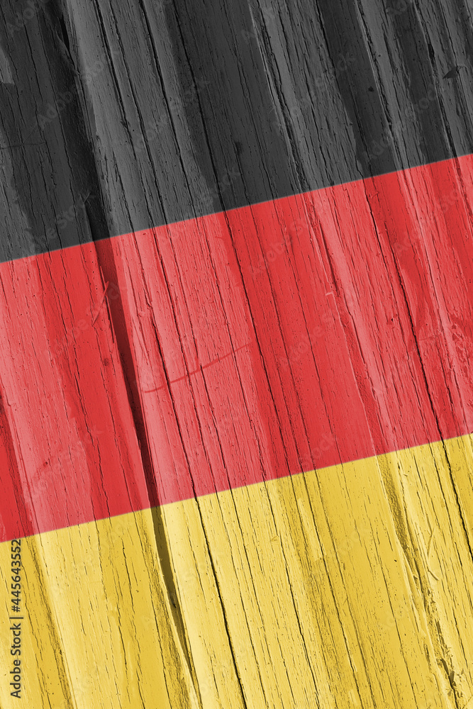 The flag of Germany on dry cracked wooden surface. It seems to flutter ...