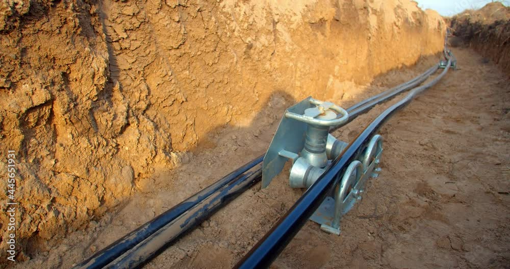 Trench for cable laying, machine is dragging the cable across, 4k สต็อก ...