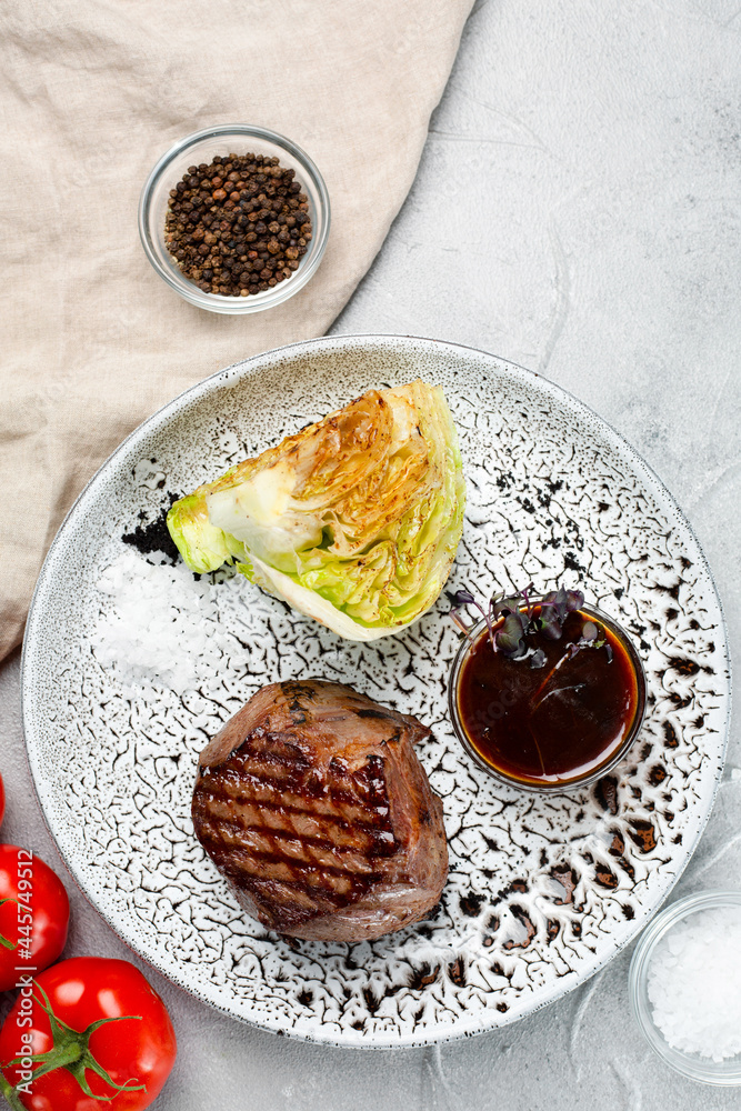 filet mignon on ceramic plate closeup on concrete table. meat with ...