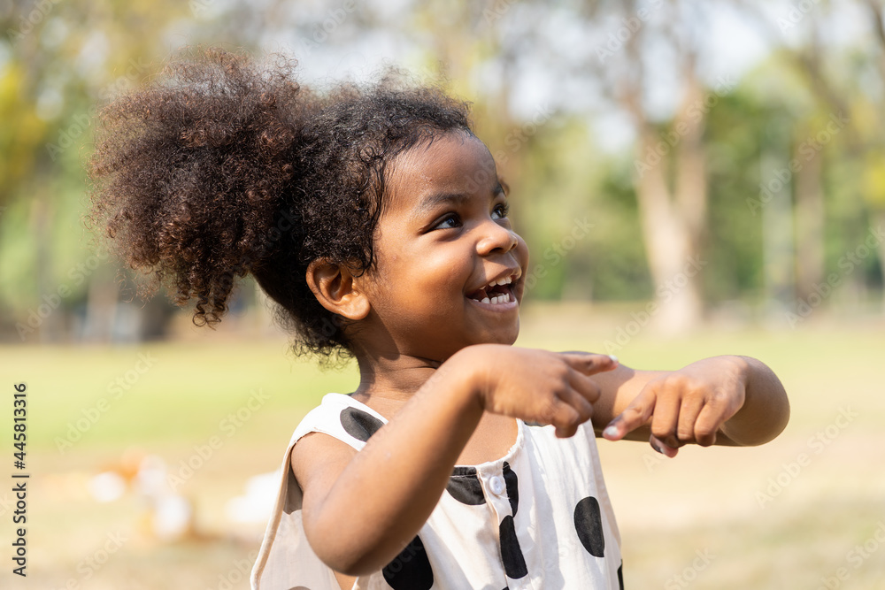 Cheerful African American toddler little girl playing outdoor in the ...
