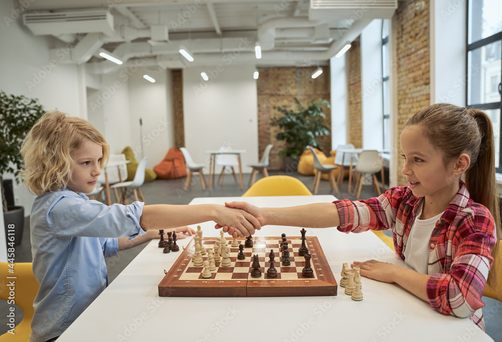 Respect. Adorable little friends, caucasian boy and girl shaking hands ...
