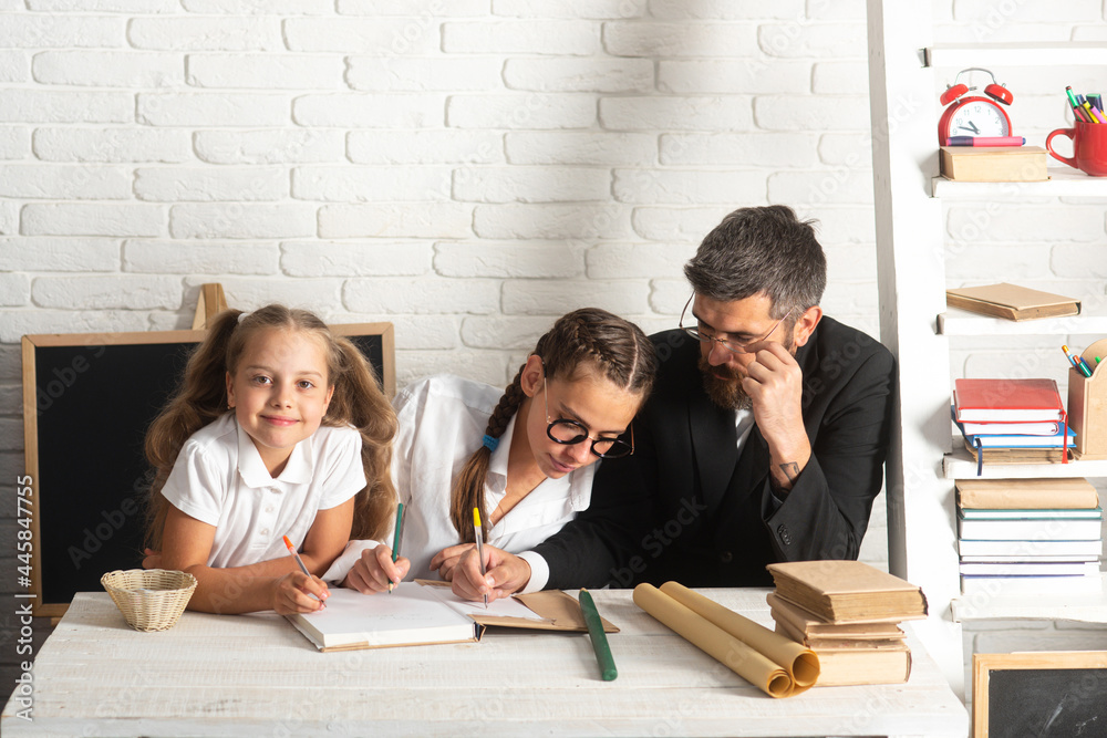 Dad teaching schoolchild girls. Father and school kids daughters at ...