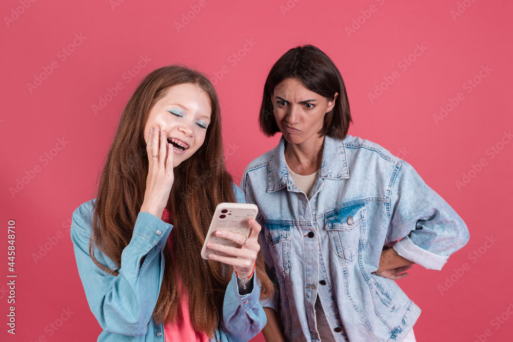 Modern mom and daughter in denim jackets on terracotta background, girl ...