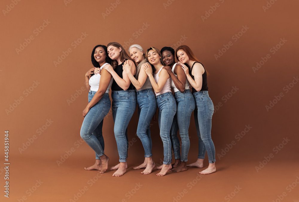 Full length of six smiling women embracing in studio. Females of ...
