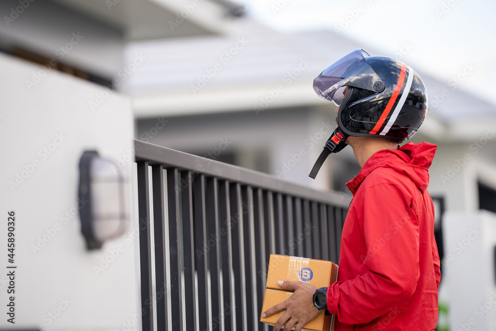 Courier in red uniform Delivery man standing with parcels in hands ...