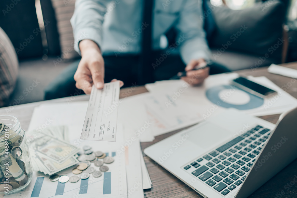 A Businessperson's hand giving cheque to customer and dollar bill, coin ...