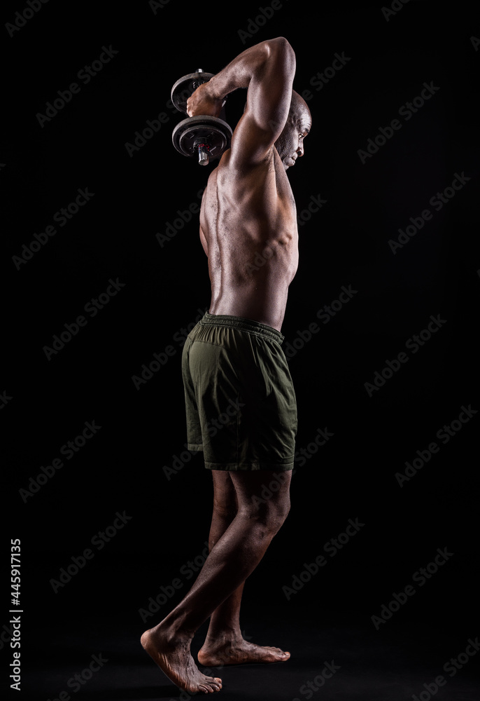 Side back view of a muscular man standing doing triceps exercise Stock ...