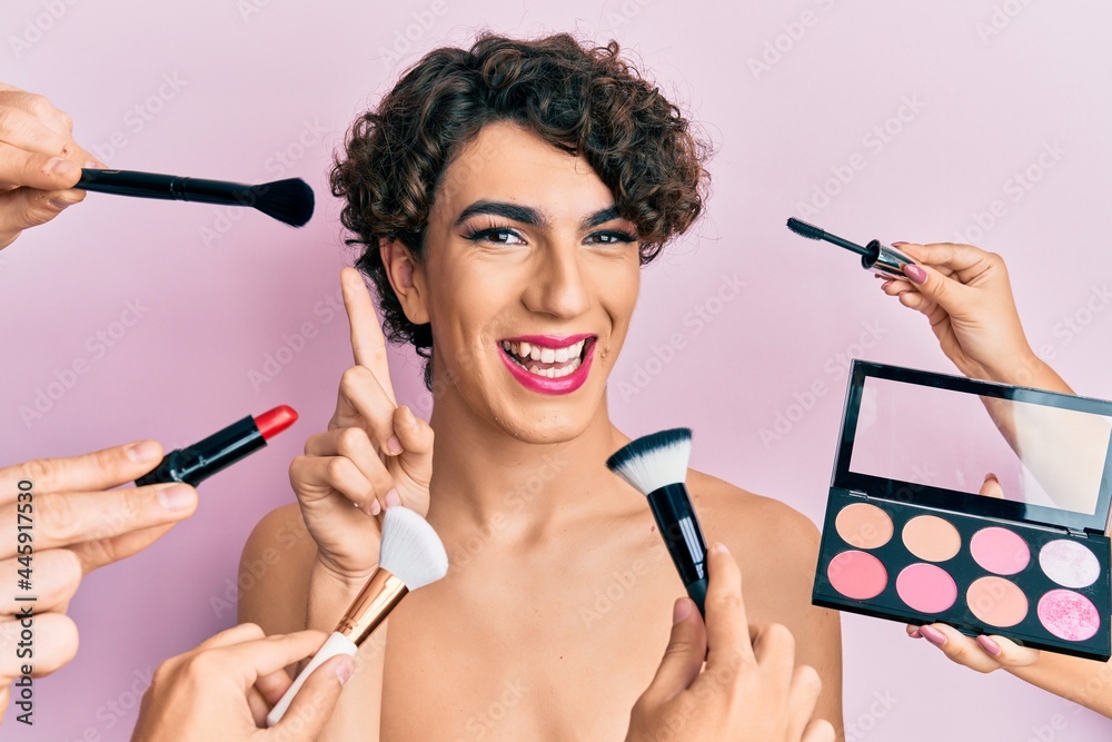 Young man wearing woman make up with stylist all around him smiling ...