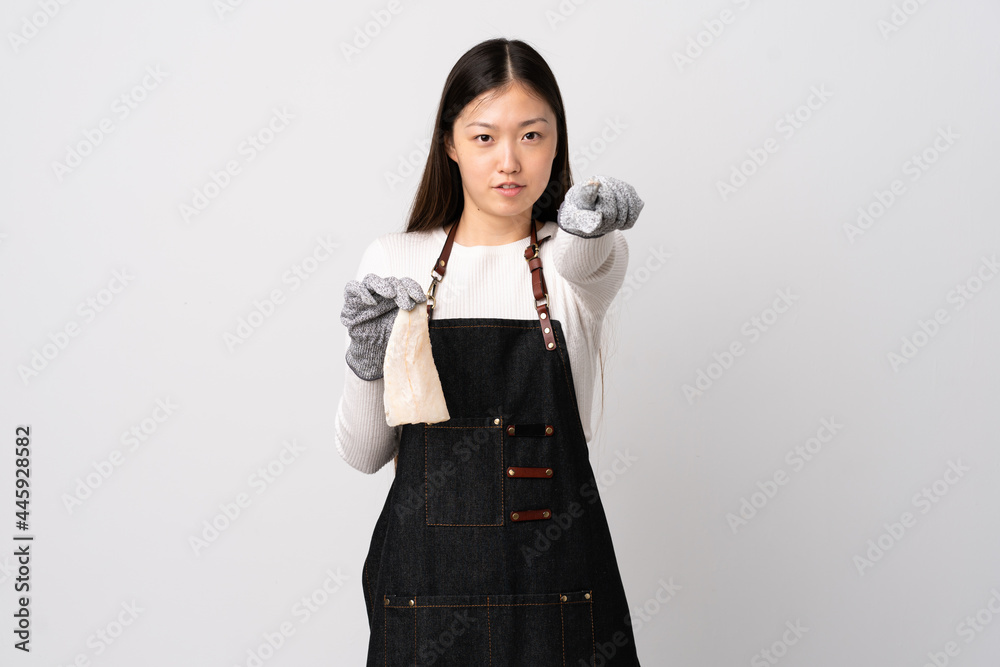 Chinese fishmonger wearing an apron and holding a raw fish over ...
