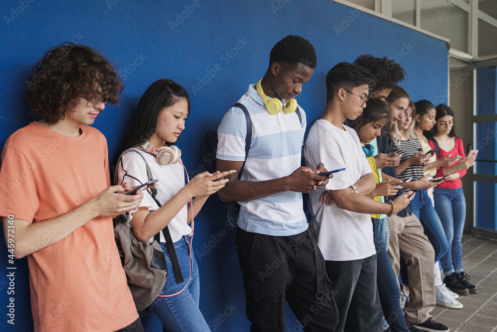 Group of multi-ethnic teenager friends using smart mobile phones in ...