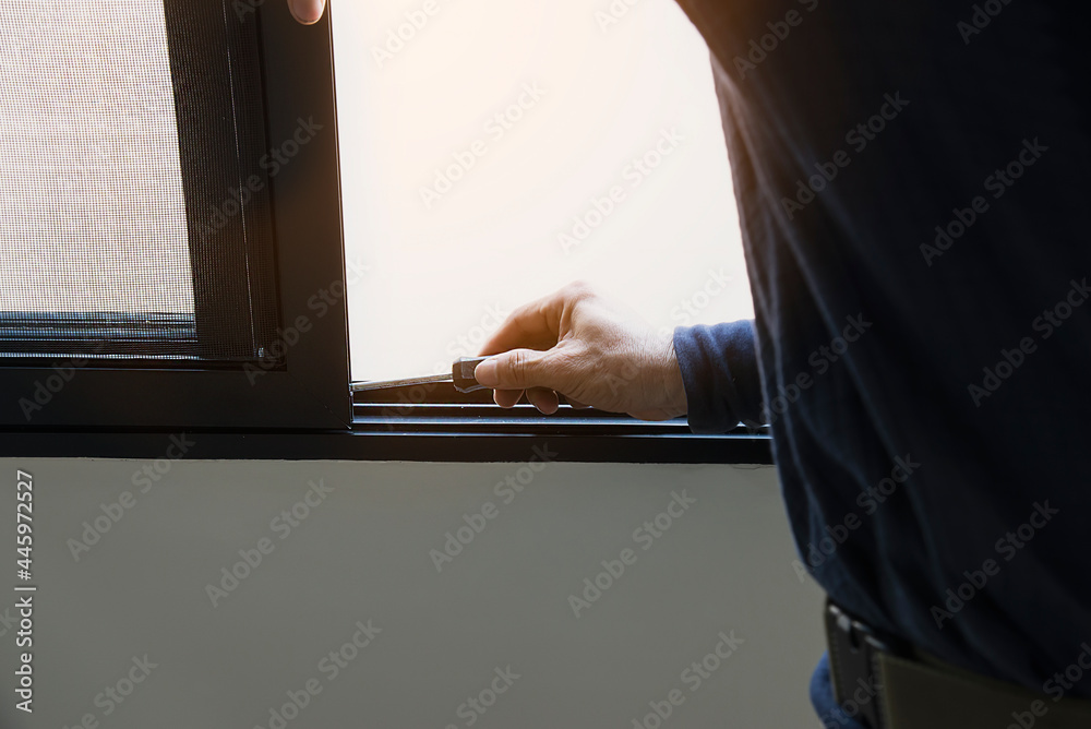Man doing aluminum frame with wire screen door and window installation ...