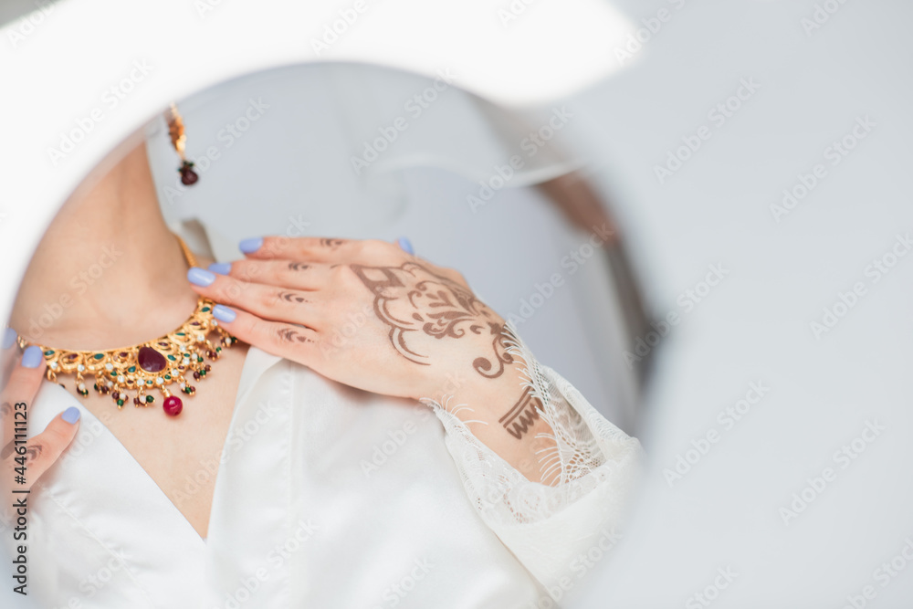 reflection in mirror of young indian bride in earring wearing necklace ...