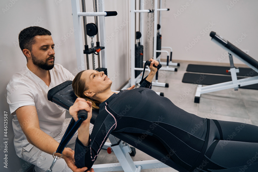 Doctor kinesiologist provides muscle therapy exercises for woman arms ...
