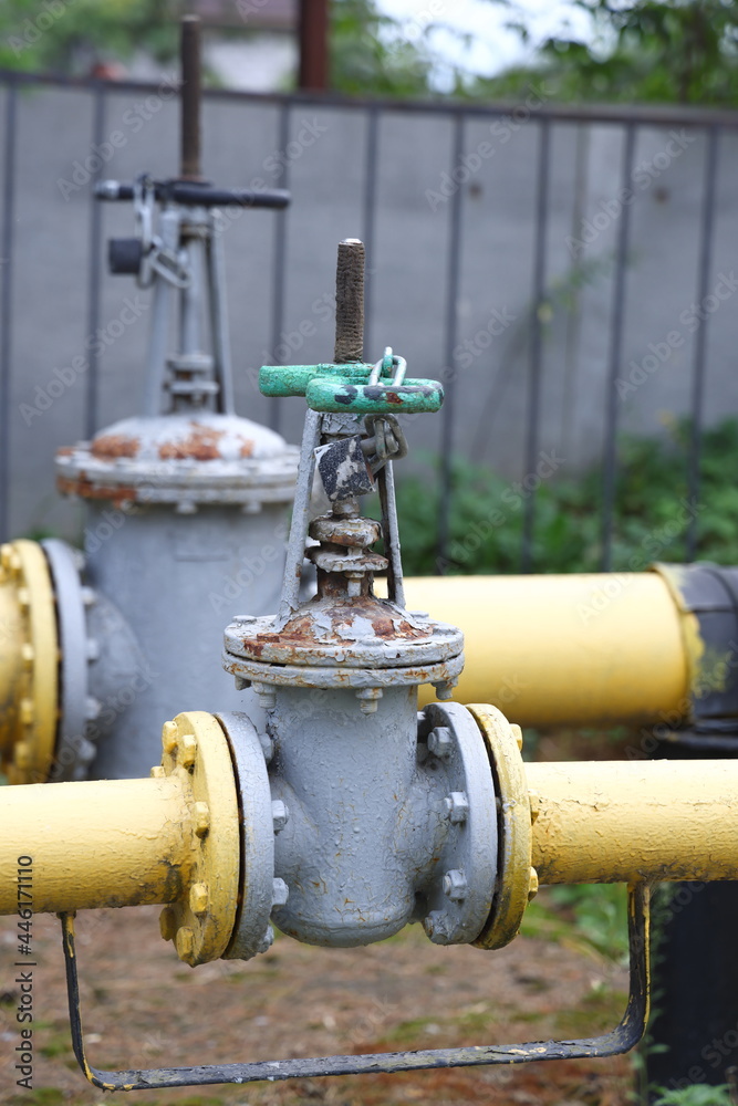 Yellow steel pipes and valve at gas distribution station, gas piping ...