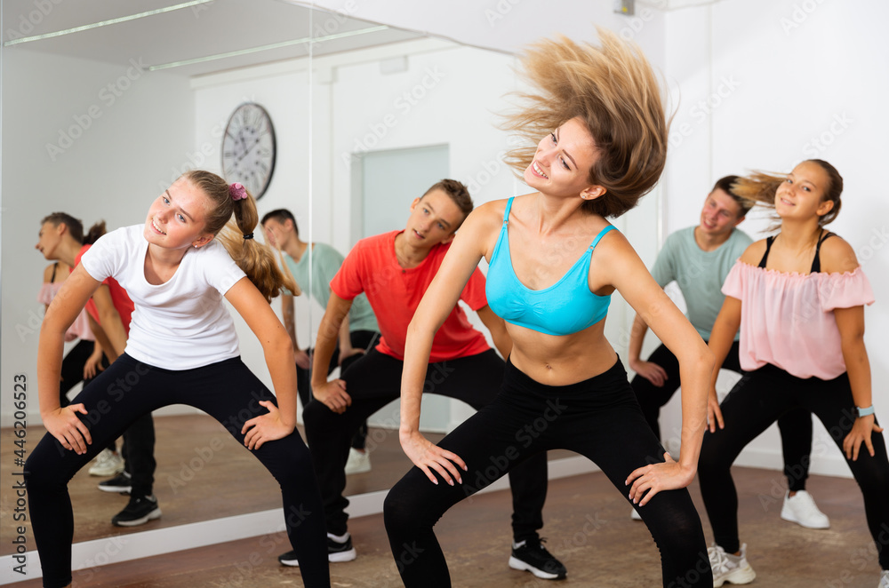 Group of teenagers participating in dance class, following their young ...