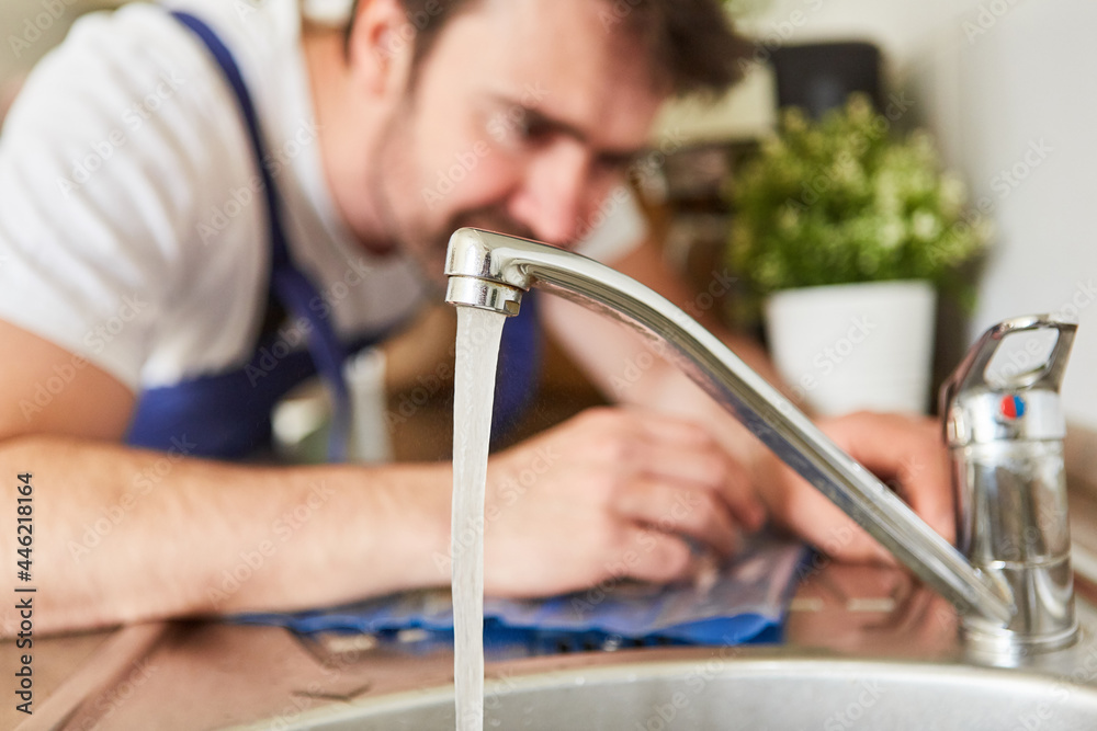 Plumber repairs mixer tap on the tap Stock Photo | Adobe Stock