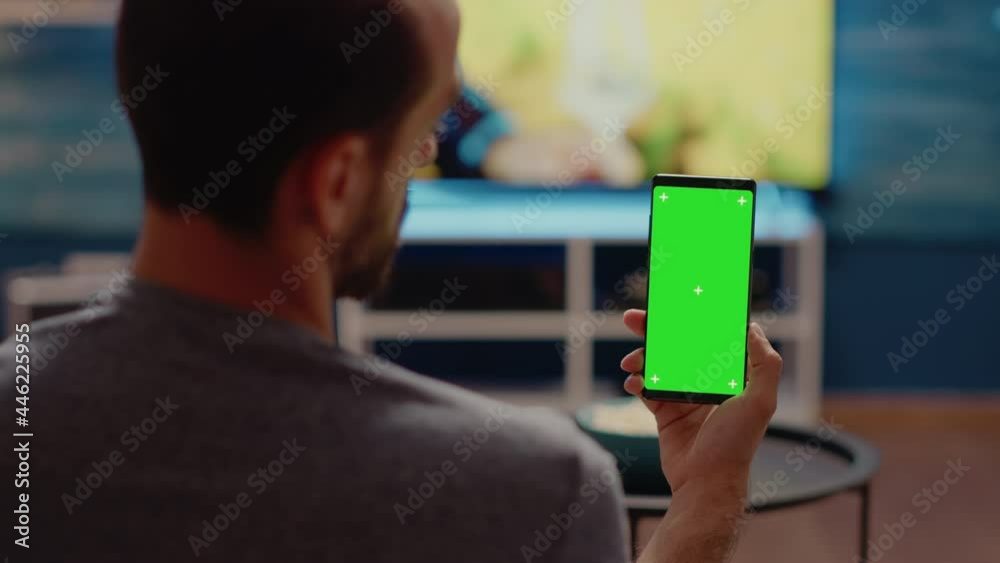 Person holding mobile phone with green screen vertically on display ...