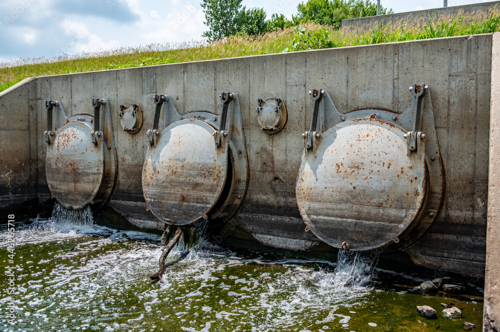 Heavy metal flood control gate discharging into a waterbody Stock Photo ...