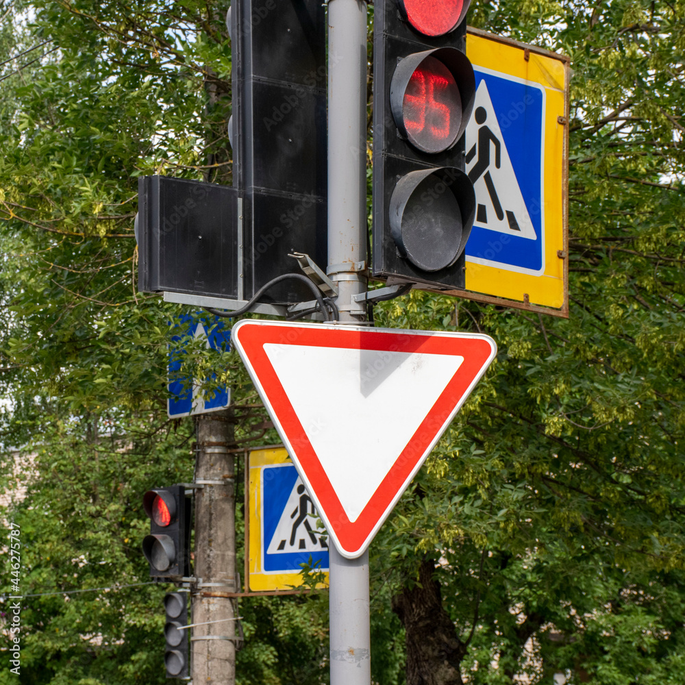 Give way road sign and red traffic light. Stock Photo | Adobe Stock