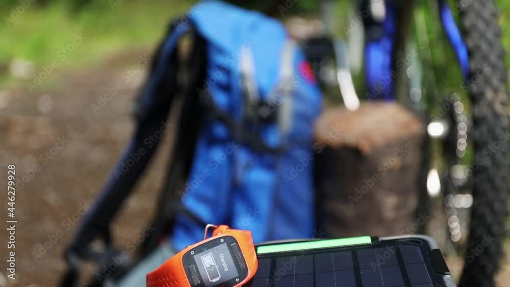 Concept of renewable energy. Portable solar panel charges a smartwatch ...