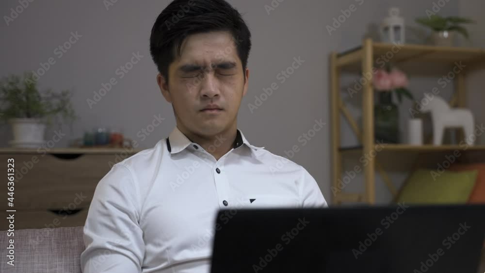 overworked asian business man waking up with a shocked look from dozing ...