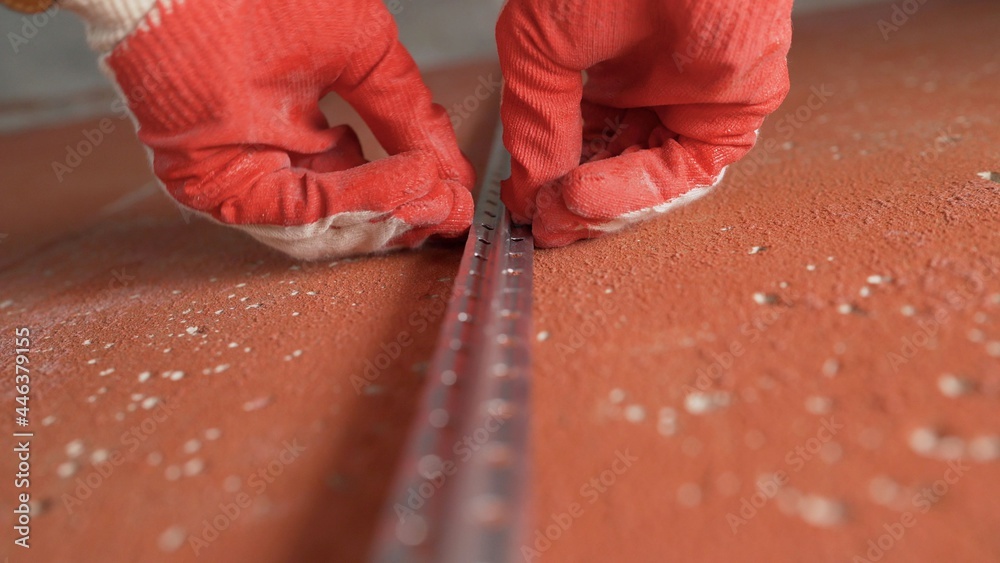 Installation of metal guiding beacons for filling and leveling of walls ...