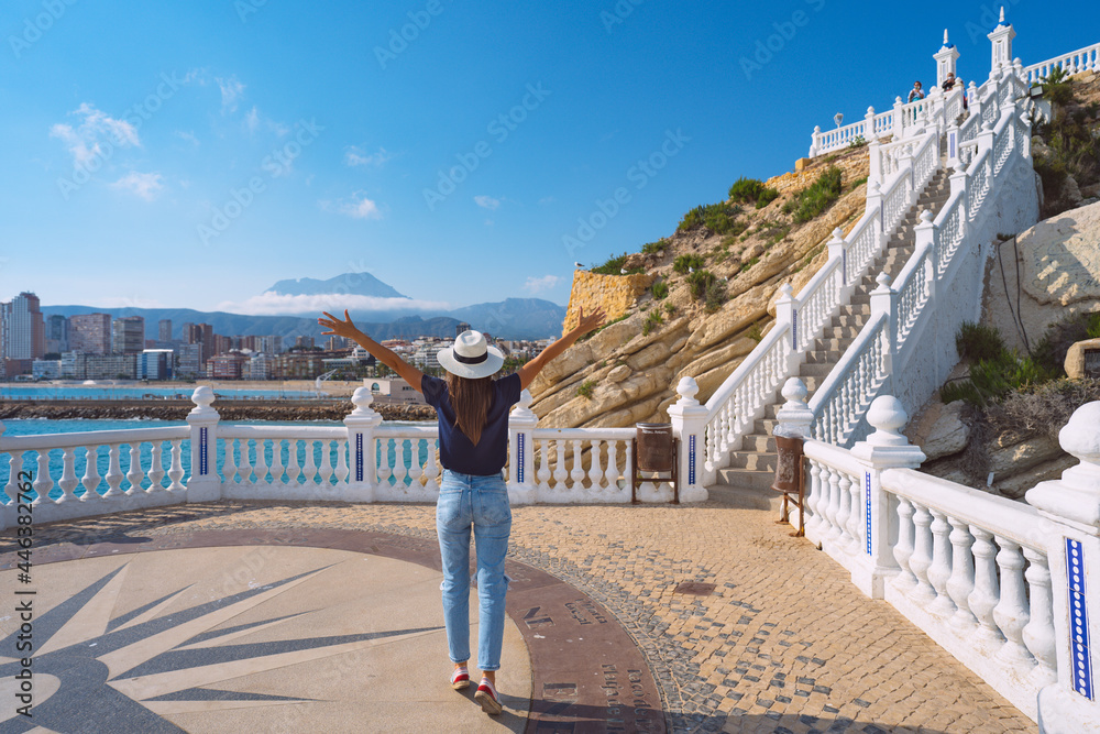 Young carefree tourist woman with open arms enjoying summer vacation in ...