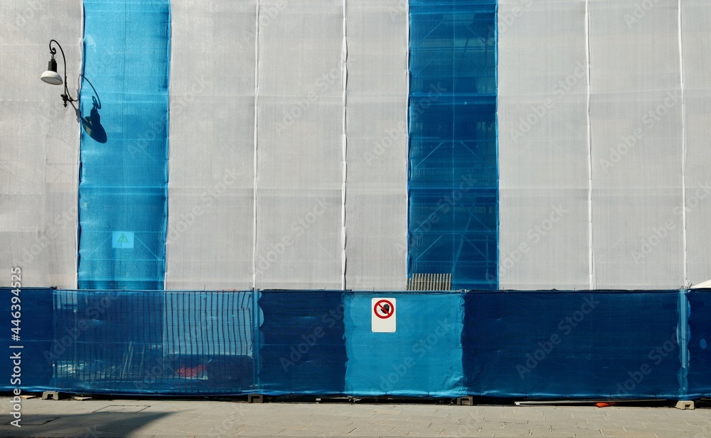 Blue and white scaffold plastic sheeting covering a facade under ...