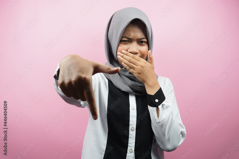 Beautiful young muslim woman with hand covering mouth, hand pointing ...