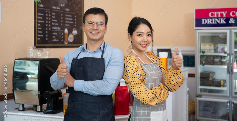 Two cheerful small business owner standing and smiling by wearing apron ...