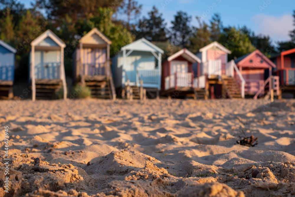 Row of characterful, colourful beach huts on the sea front at Wells ...