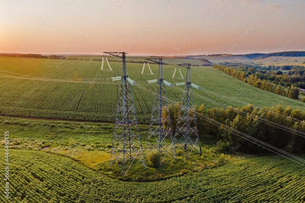 Overhead power line transmission tower at sunset. Electricity pylon and ...