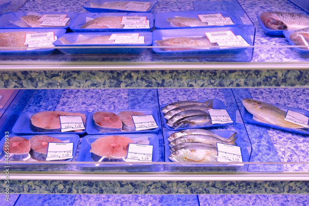Low selection of pre packed fresh raw fish displayed on shelves for ...