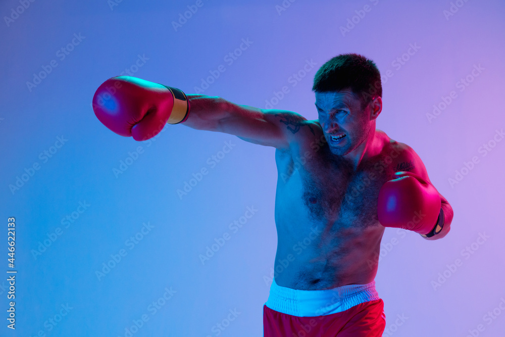 Caucasian man, professional boxer in sportwear boxing on studio ...