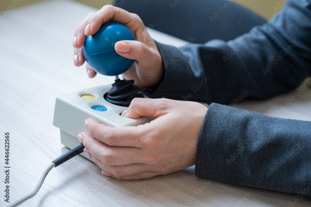 Woman with cerebral palsy works on a specialized computer mouse. Stock ...