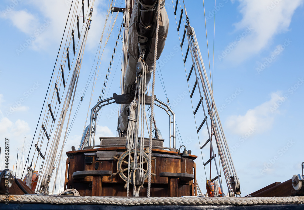 Old wooden sailing ship, closeup. Wooden steering wheel, ropes, rope ...