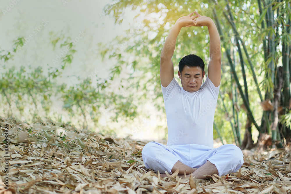 Handsome Asian man sit and do meditation yoga alone in forest. Feel ...