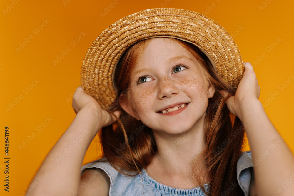 Dreamily little girl with freckles smiles and looks up. Cheerful ...