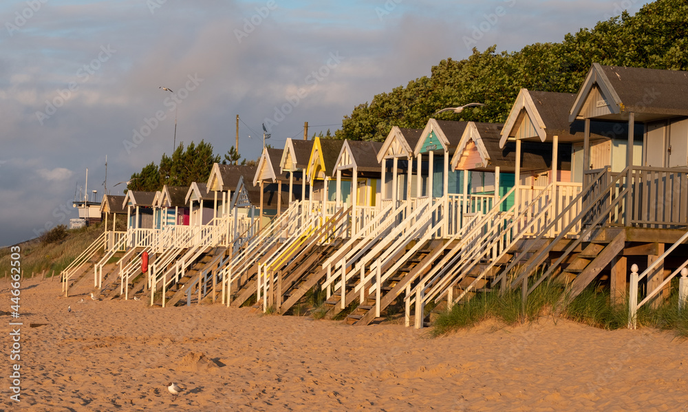 Row of characterful, colourful beach huts on the sea front at Wells ...