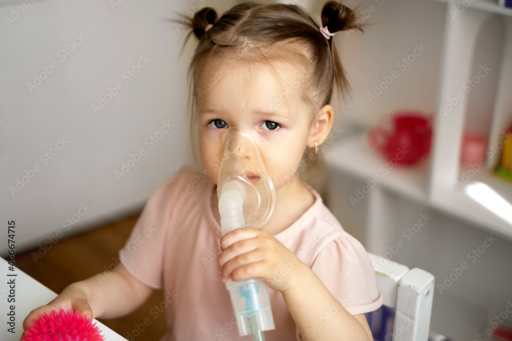 A girl breathes into an inhalation mask. Children's diseases ...