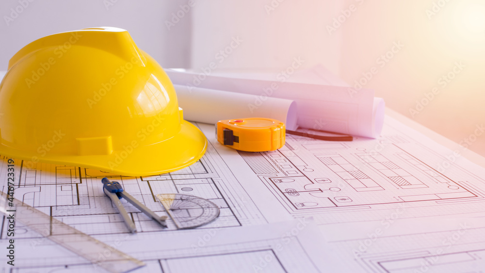 Yellow helmet and heap of drawing a project on a work desk. Project ...