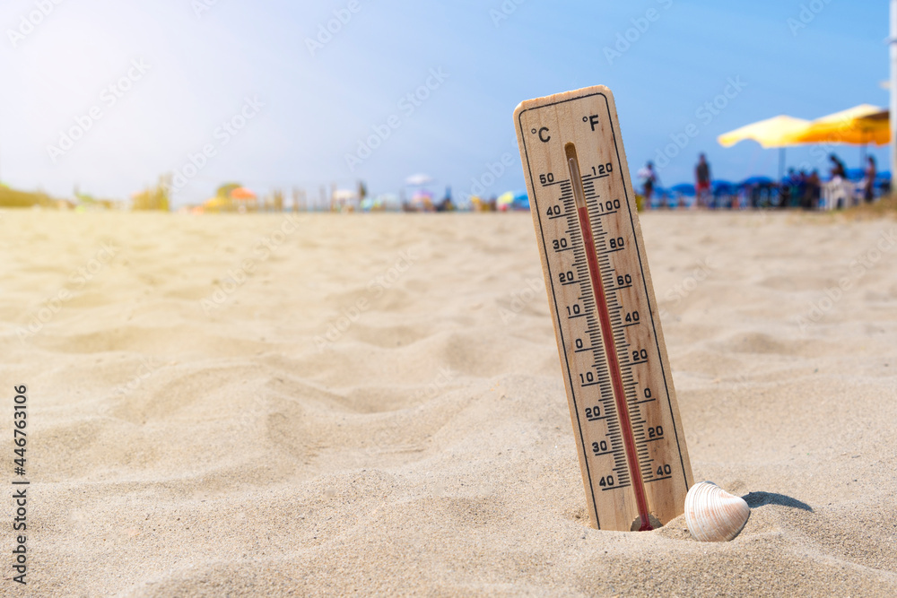 Wooden thermometer buried in the sand of an Italian beach show ...