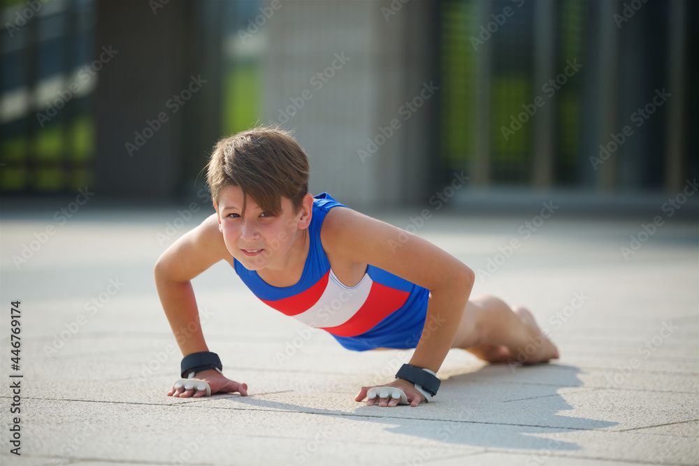 Boy gymnast school age in a suit shows the elements of the sport. Stock ...