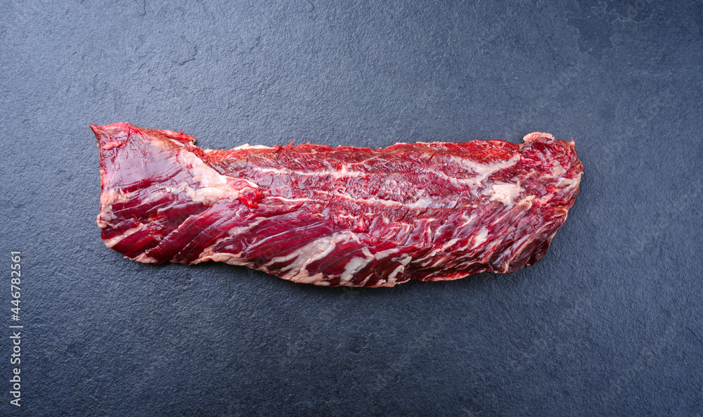 Raw wagyu onglet beef steak offered as top view on a black board with ...