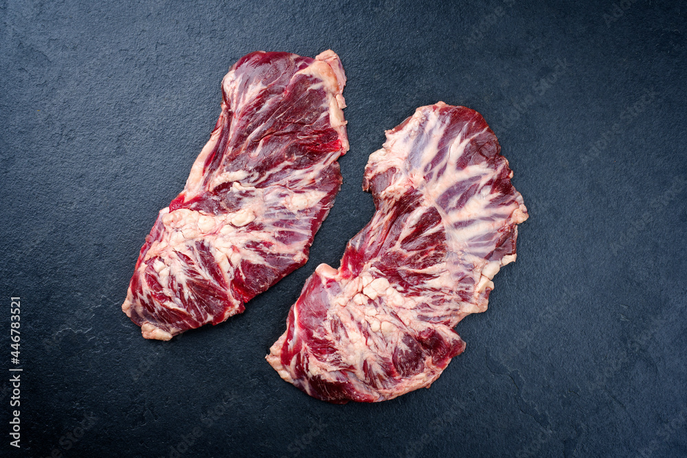 Raw wagyu spider beef steak offered as top view on a black board with ...